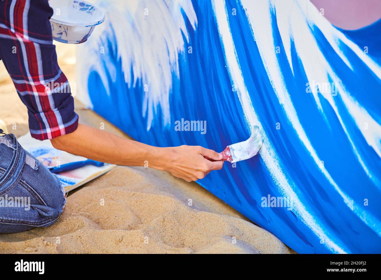 Female artist working on abstract acrylic painting, hand moving paint ...