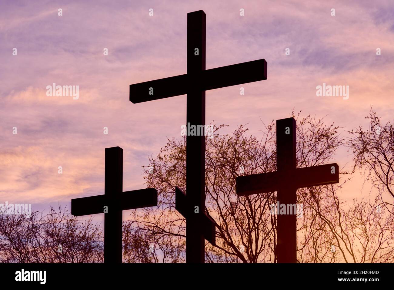 Three crosses in silhouette at sunset, dramatic sky background ...