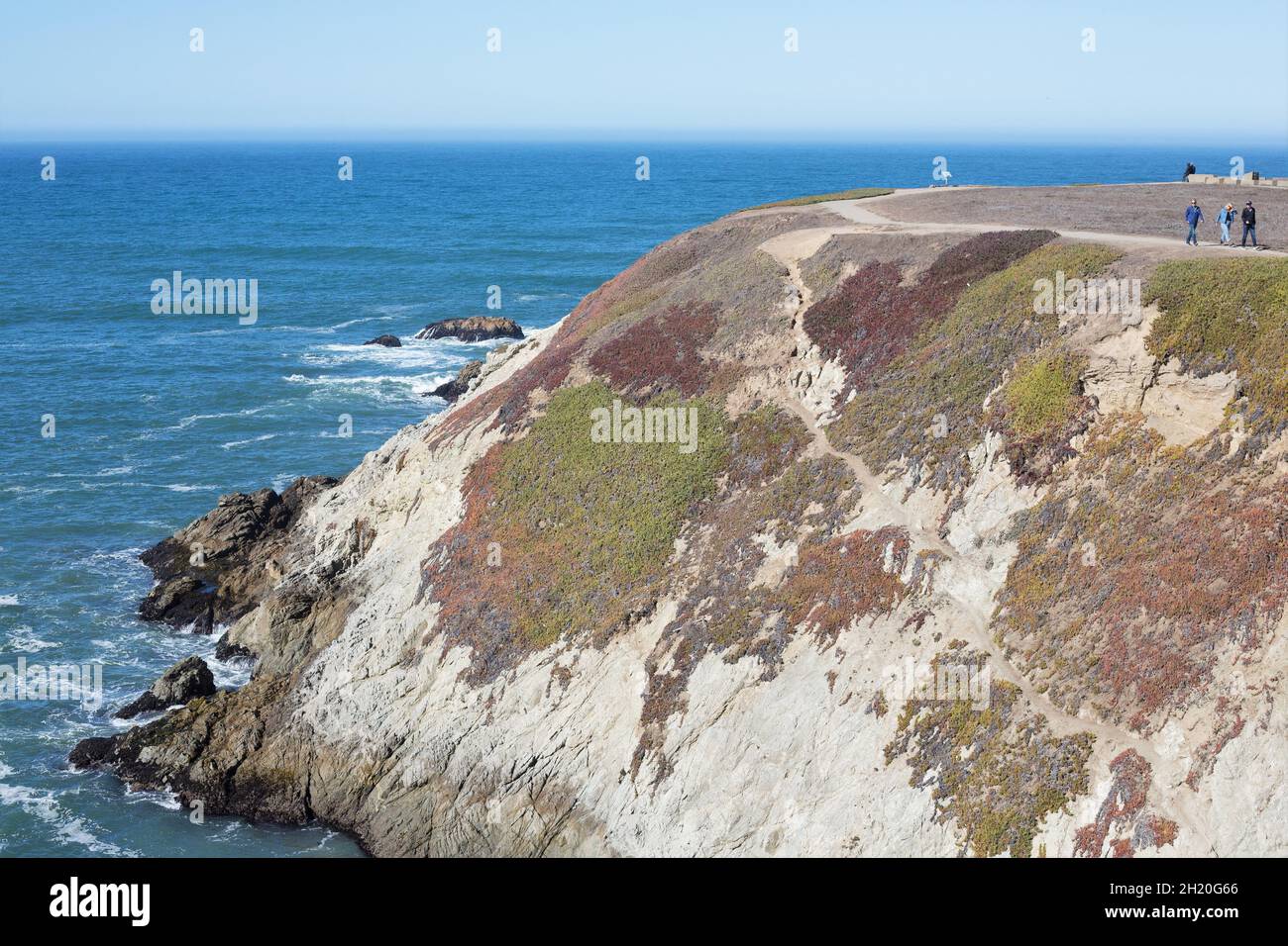 People hiking along a cliffside trail at Bodega Head in California ...