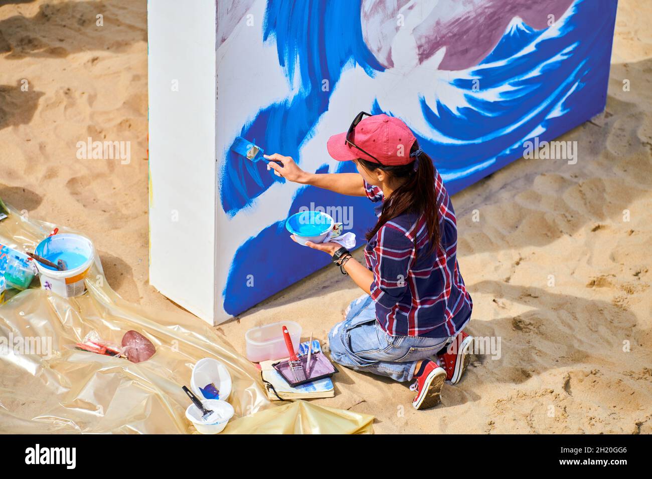 Female painter working on abstract oil painting moving paint brush ...