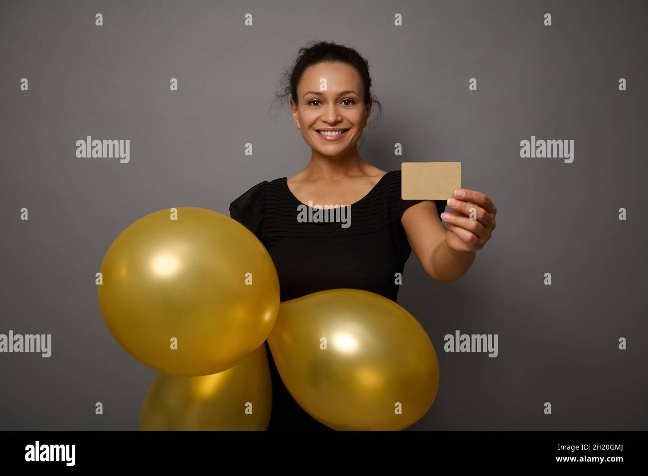 Beautiful smiling young happy woman dressed in black outfit shows ...