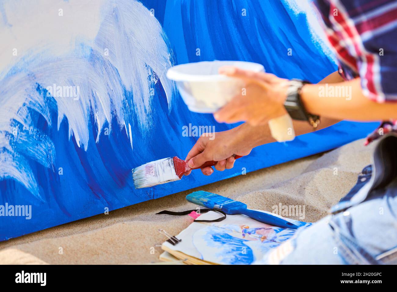 Female artist working on abstract acrylic painting, hand holding paint ...