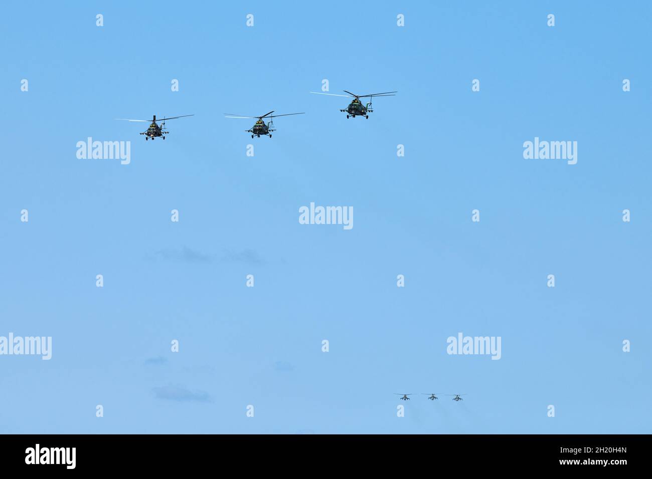Military helicopters flying in bright blue sky performing demonstration ...