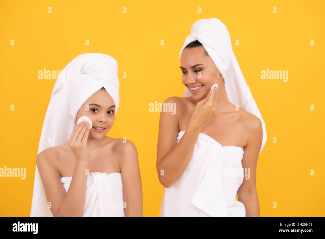 mother and daughter use cotton pads taking off makeup cleaning face ...