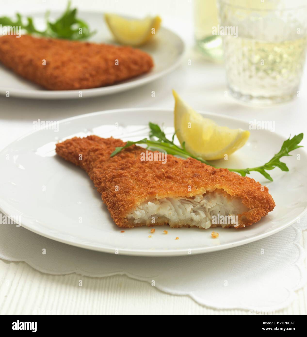 Breaded cod fillets with lemon and rocket Stock Photo - Alamy