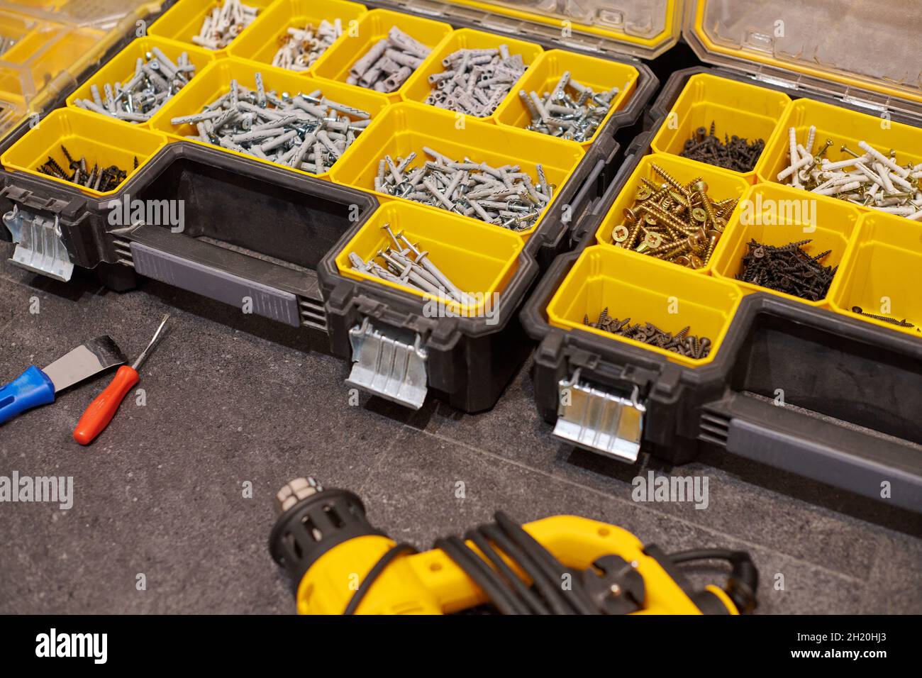 Two storage boxes on floor with small construction objects. Many ...