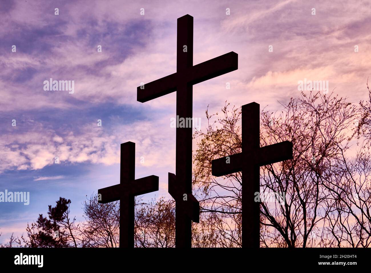 Three crosses in silhouette at sunset, dramatic sky background ...