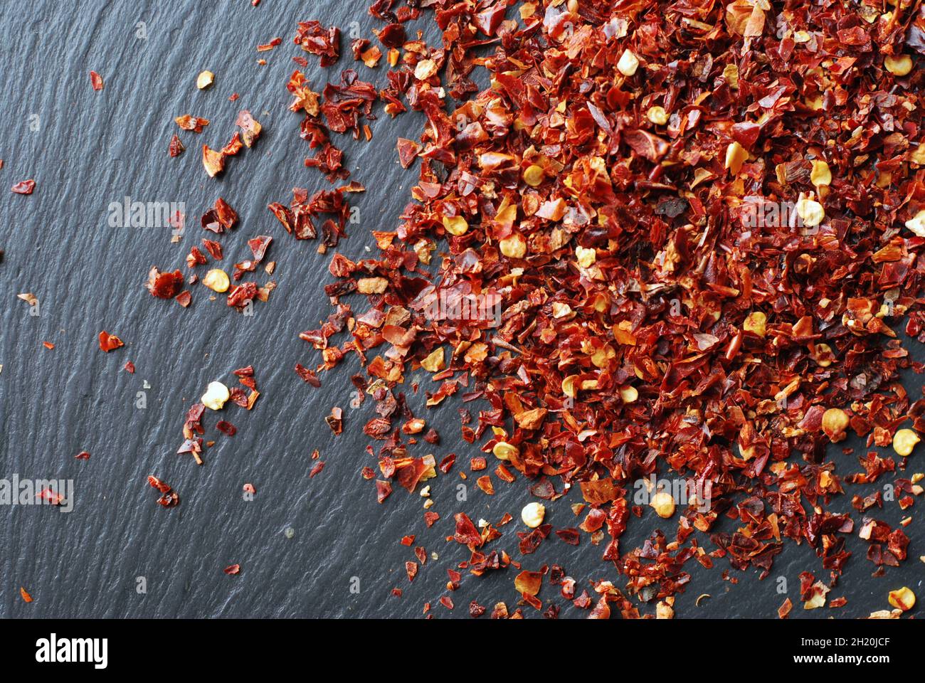 Close-up of crushed red chilli spice on clack background Stock Photo ...