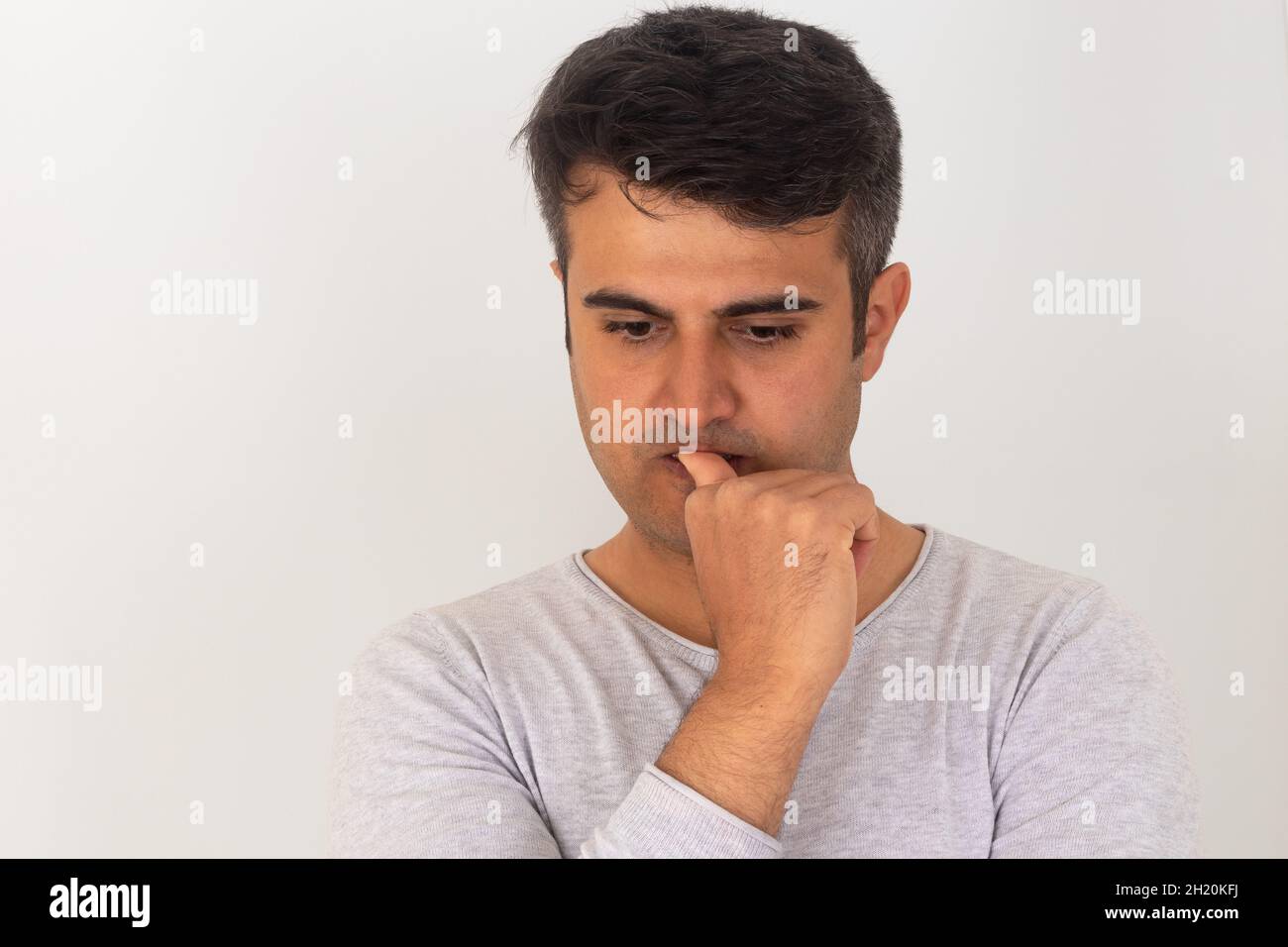Stressed man biting finger nails on isolaned background Stock Photo - Alamy