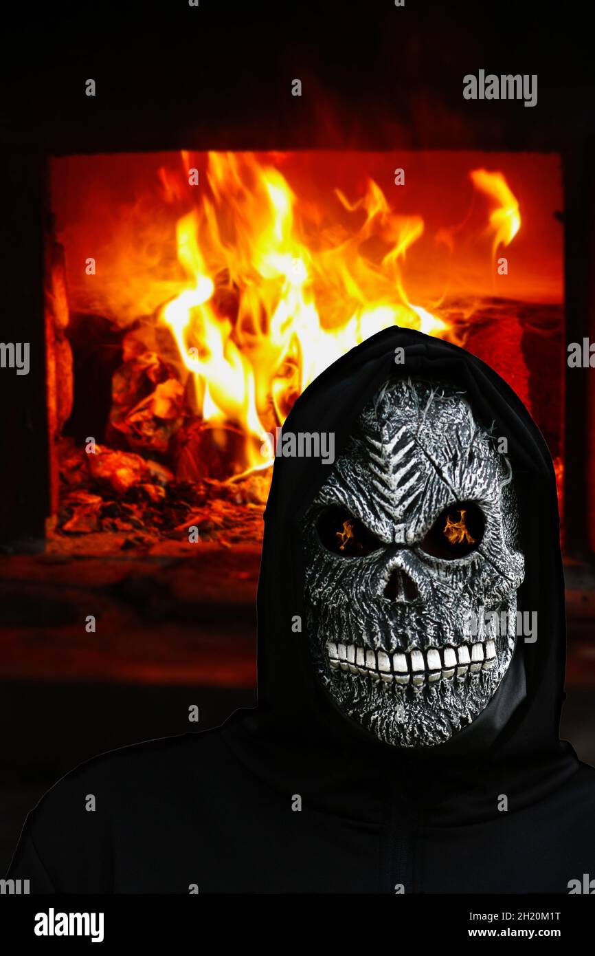Close-up portrait of grim reaper. Man in death mask with fire flame in ...