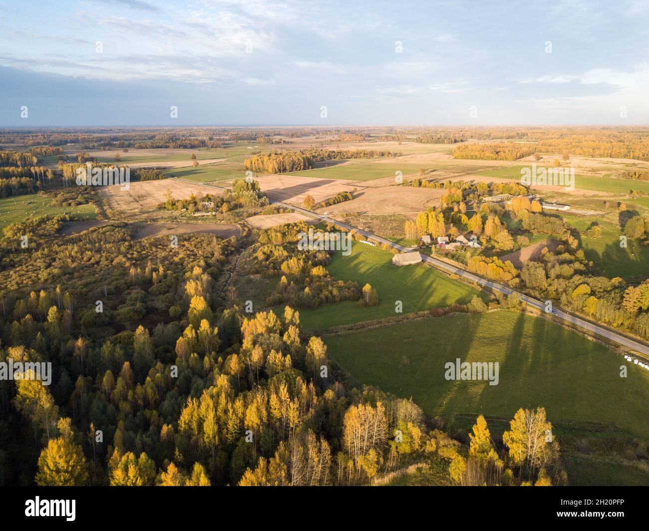 countryside roads in autumn colors with sunset light. drone image above ...