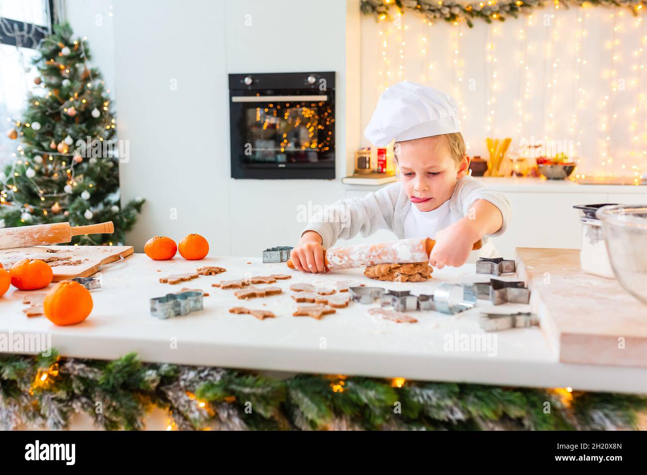 Cute little boy making gingerbread, cutting cookies of gingerbread ...