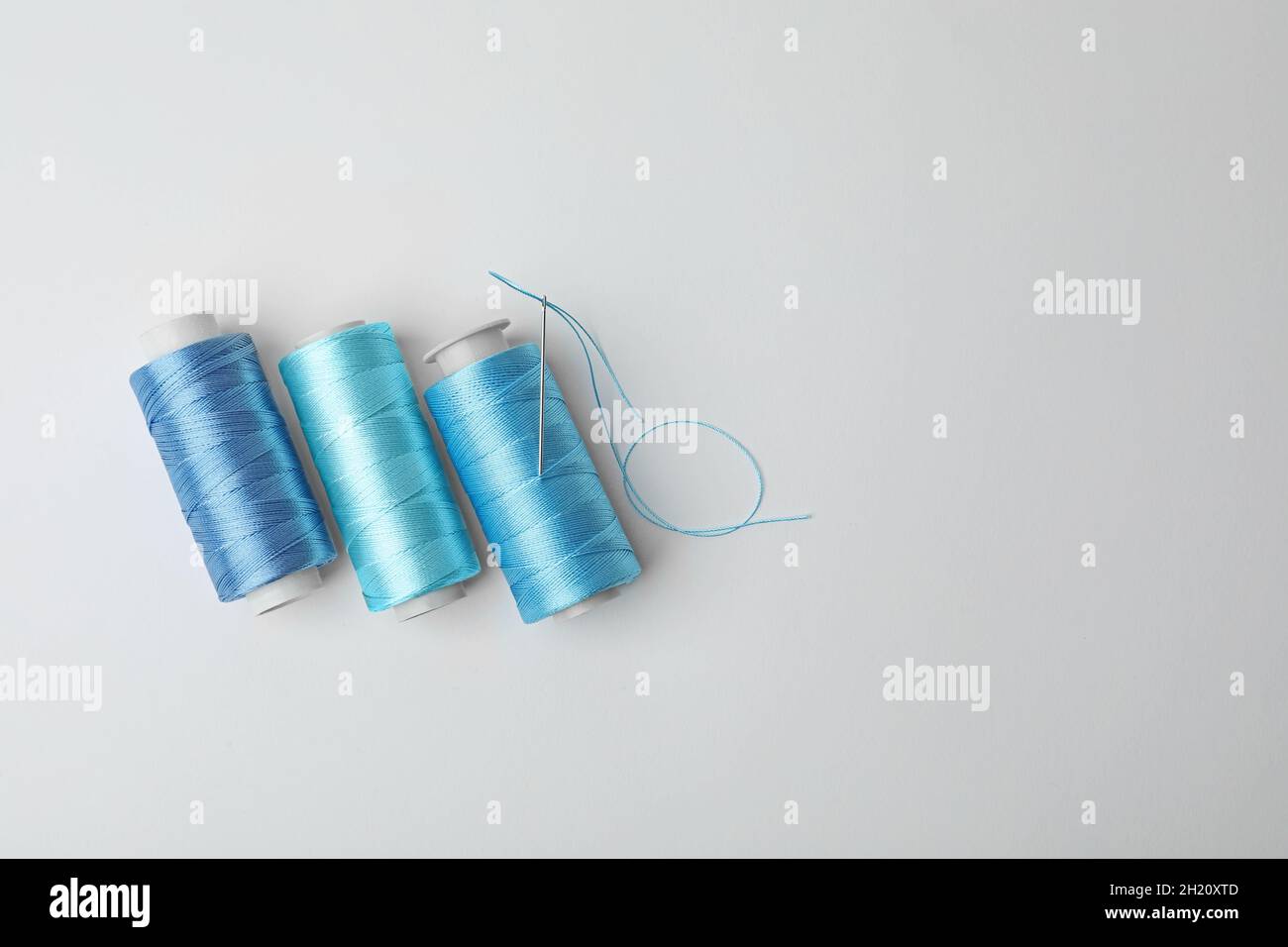 Color sewing threads on white background, top view Stock Photo - Alamy