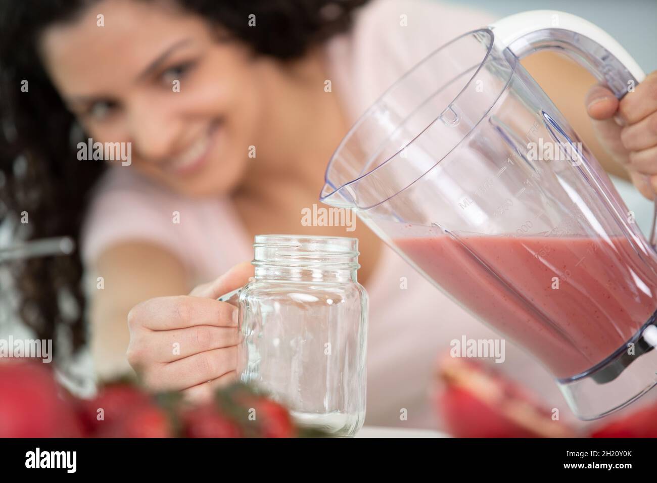 woman with blende pouring milk shake to glass at home Stock Photo - Alamy
