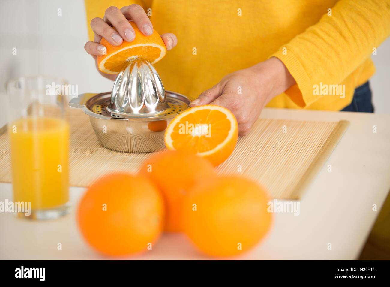 female hand crushes orange on white background Stock Photo - Alamy