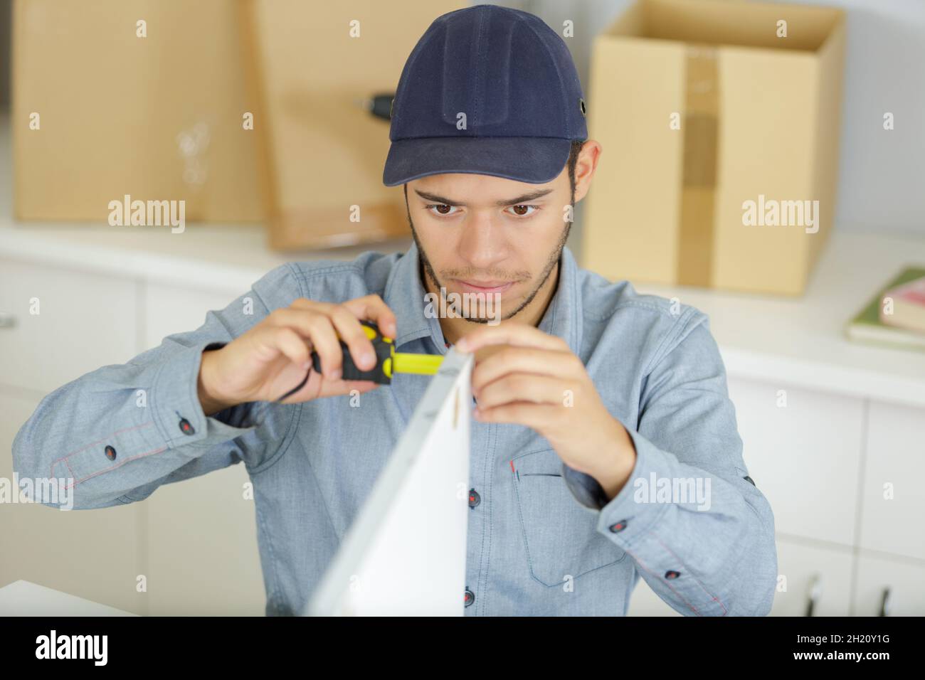 man measuring wood piece for furniture assembling Stock Photo - Alamy