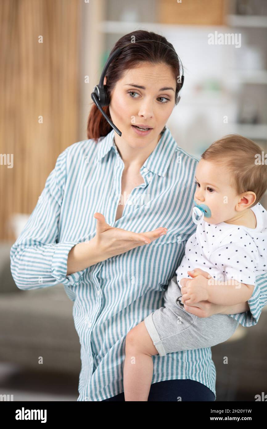 busy businesswoman working with baby on lap Stock Photo - Alamy