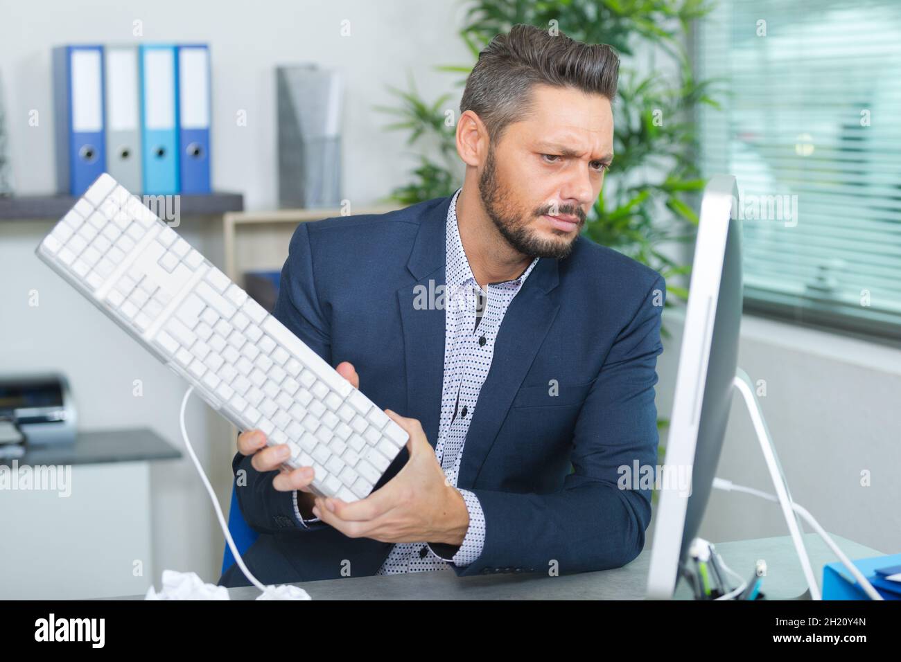 angry businessman throwing keyboard at computer screen Stock Photo - Alamy