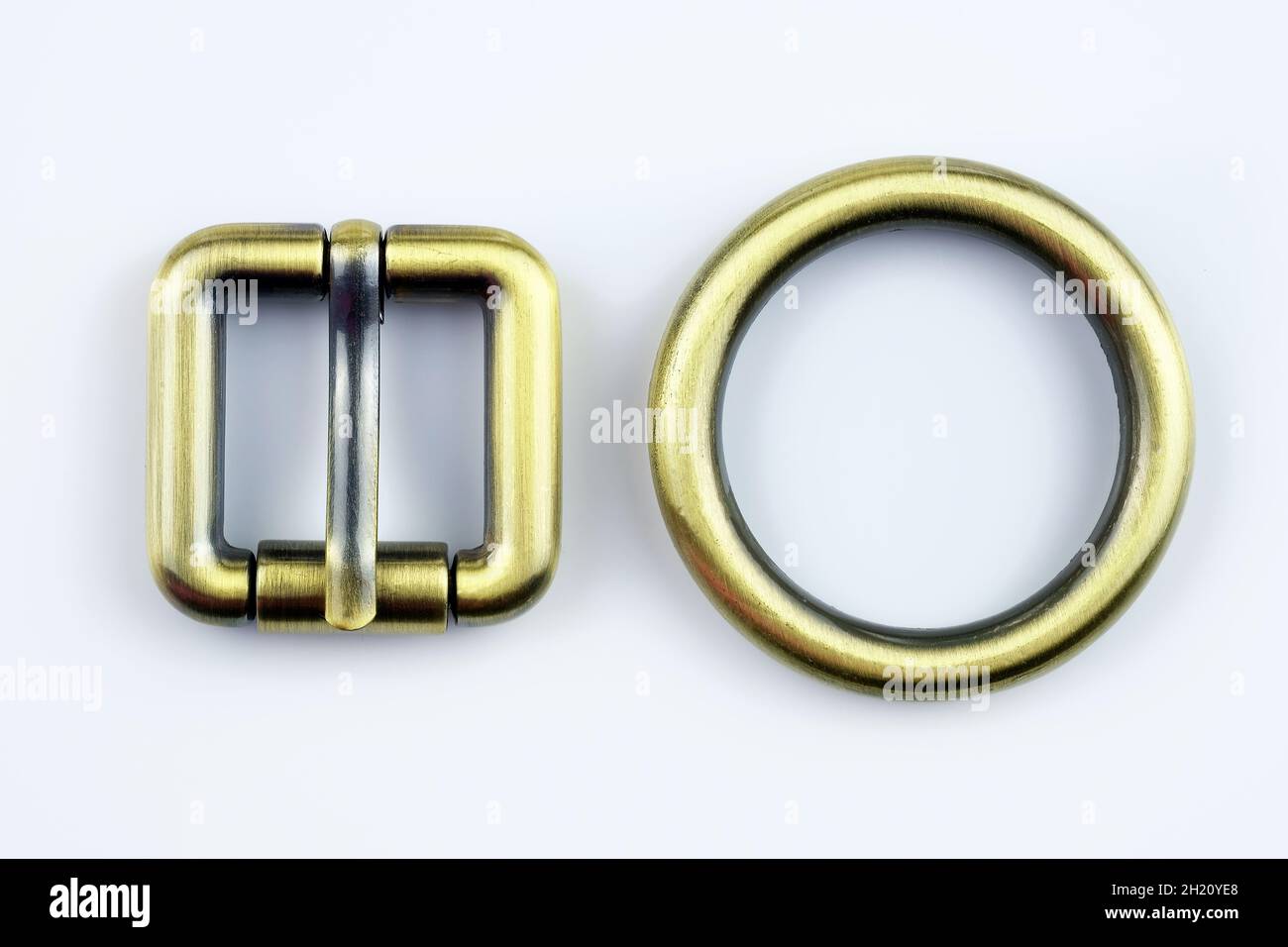 Square bronze buckle with a flat tongue and metal ring on a white ...