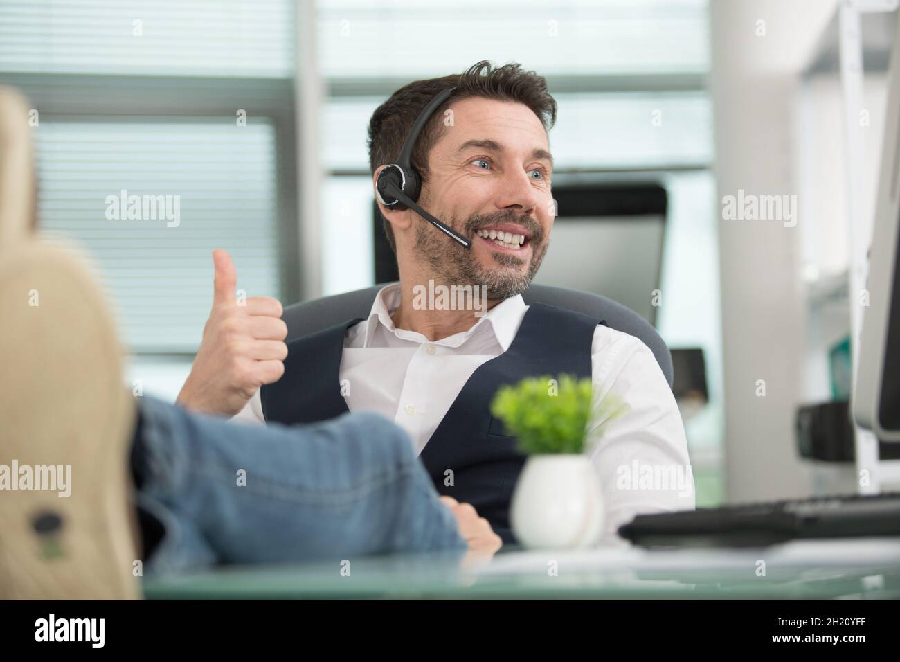 happy support center worker working on his computer Stock Photo - Alamy