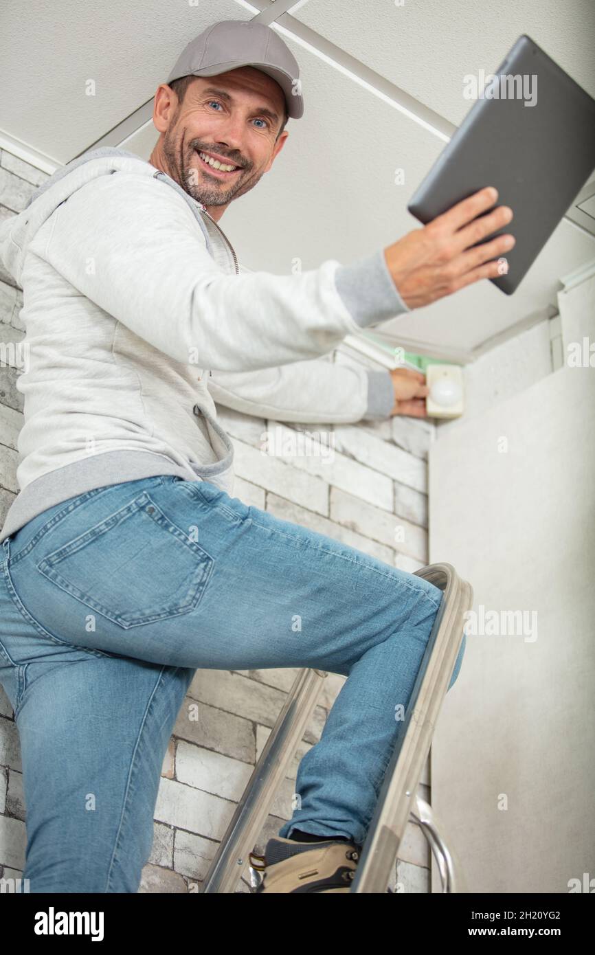 builder on ladder holding tablet Stock Photo - Alamy