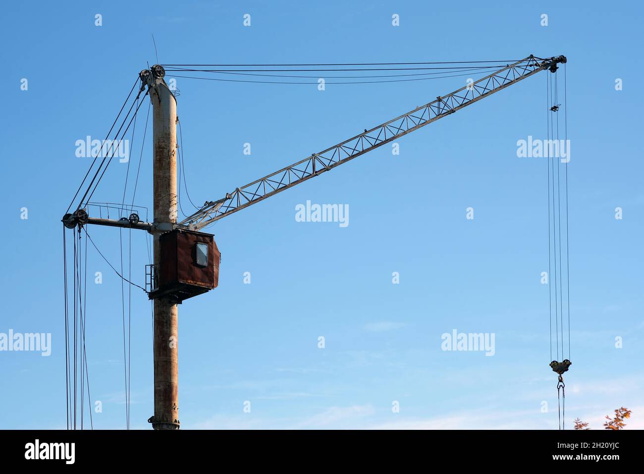 Old rusty construction crane against the background of the sky. Old ...