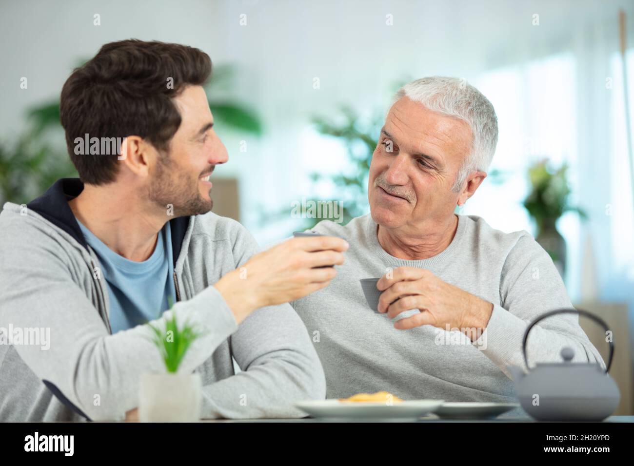 happy father and son communicating while having tea Stock Photo - Alamy