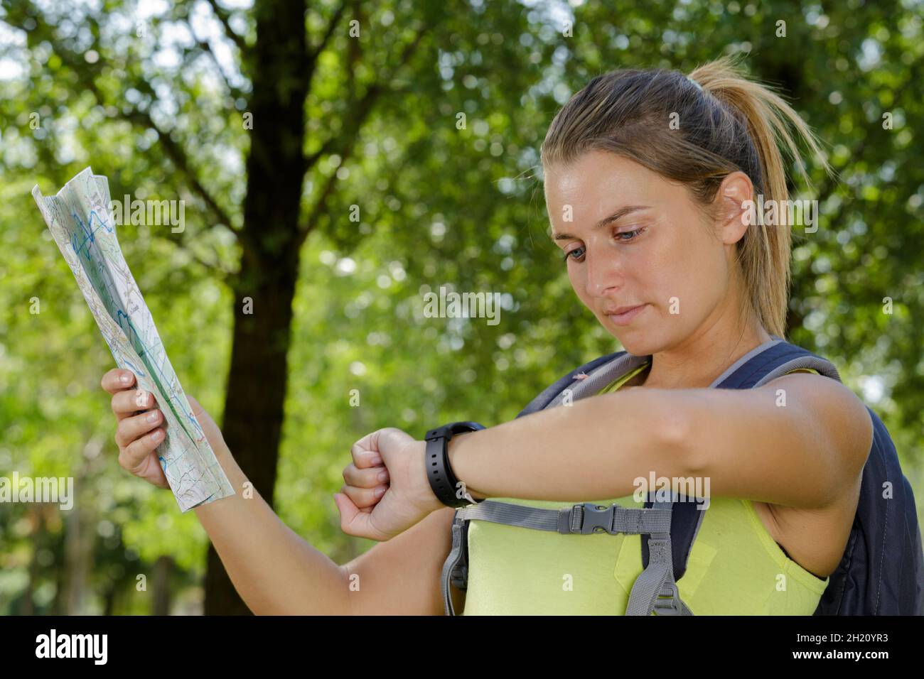 woman looking at her watch holding map Stock Photo - Alamy