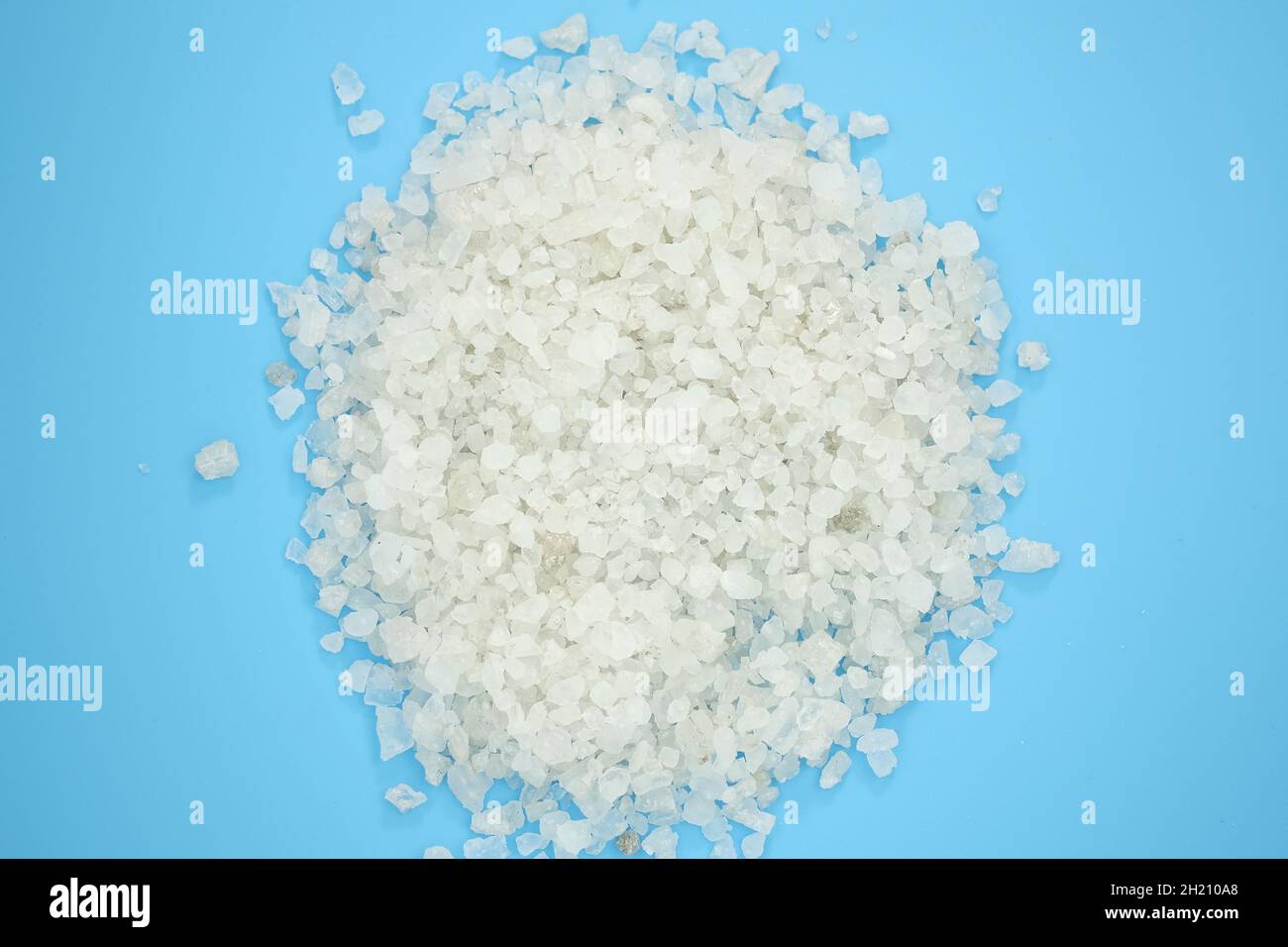 White sea salt grain top view. Coarse salt on a blue background. Pile ...