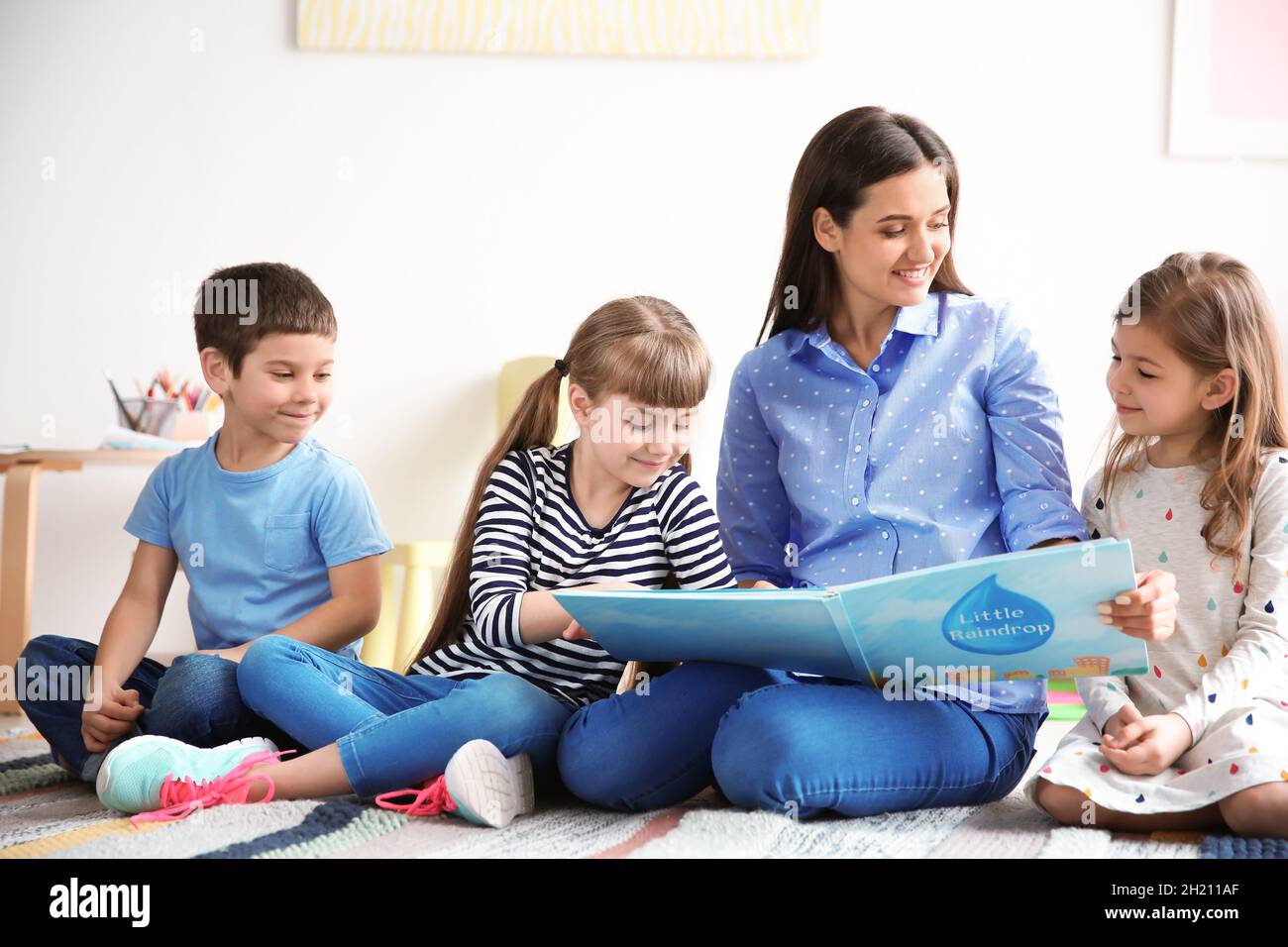 Cute little children with teacher in classroom at school Stock Photo ...