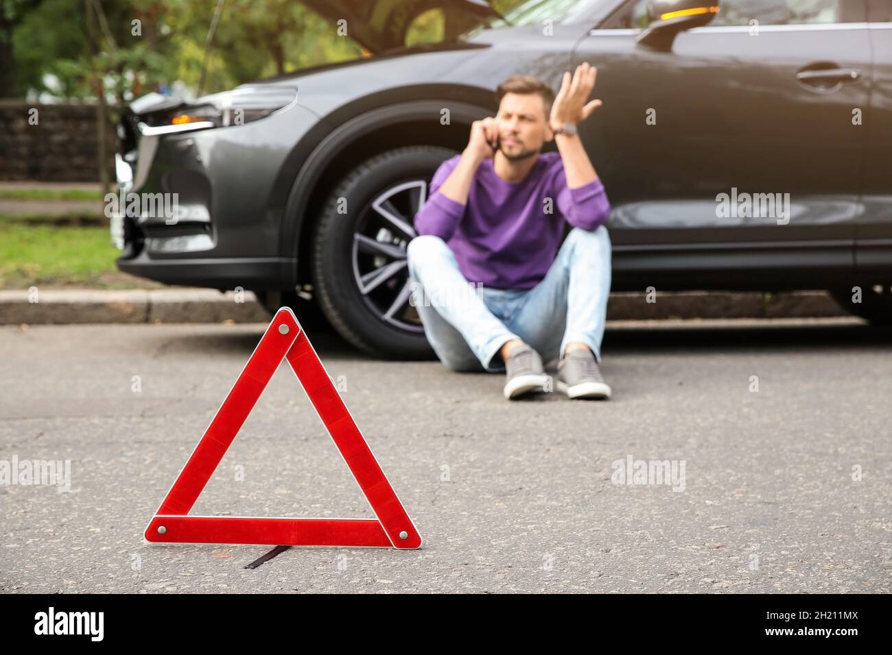 Emergency stop sign and man near broken car on background Stock Photo ...