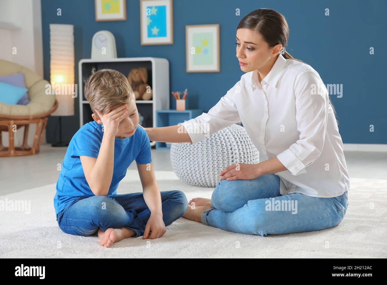 Female psychologist calming cute little boy in office Stock Photo - Alamy
