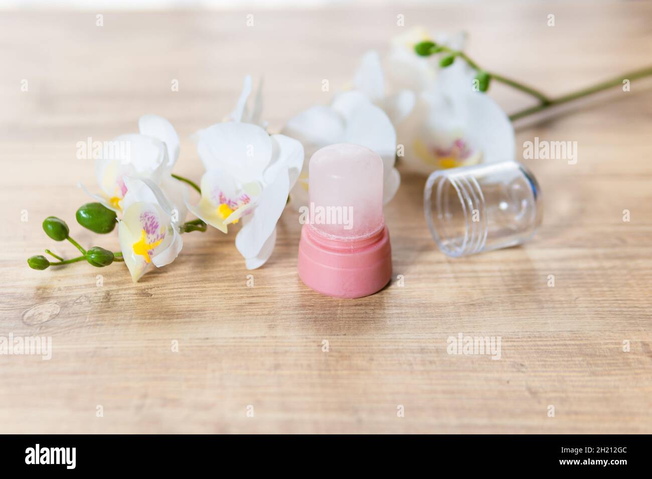 Natural eco crystal alum deodorant and orchid branch with flowers on ...