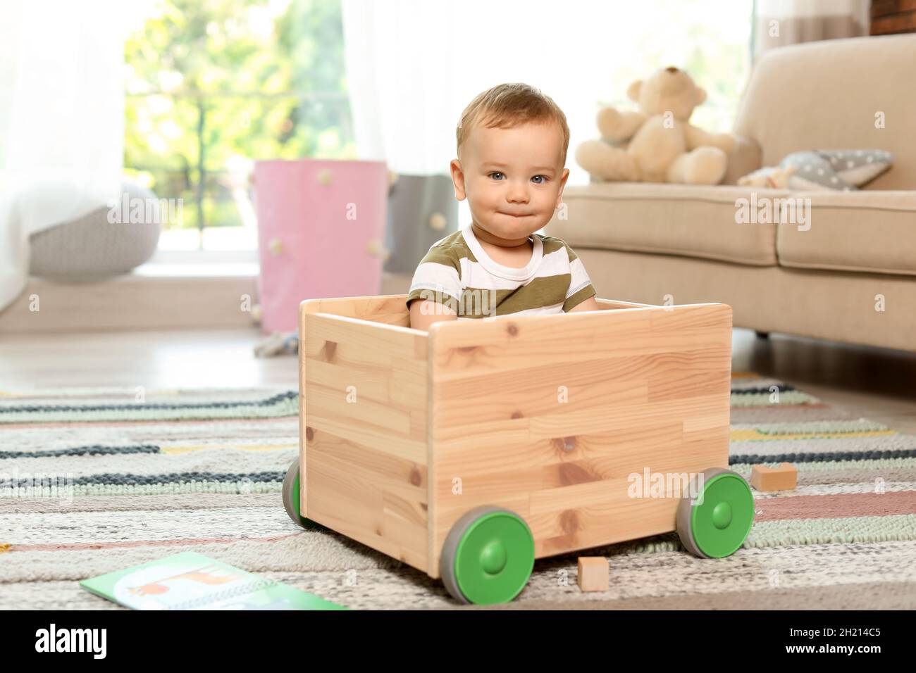 Adorable little baby in wooden cart at home Stock Photo - Alamy