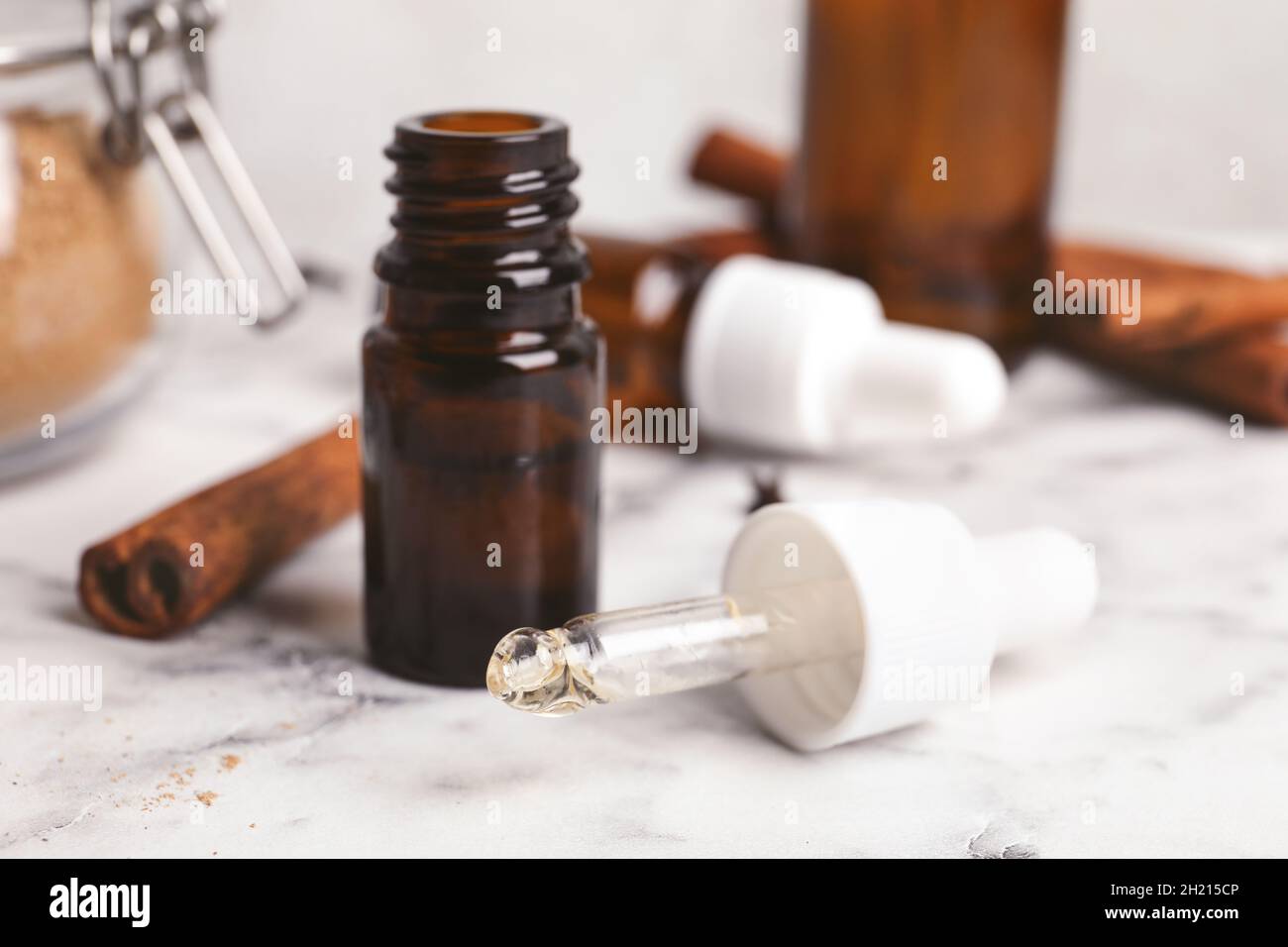 Bottle and pipette with cinnamon essential oil on table Stock Photo - Alamy
