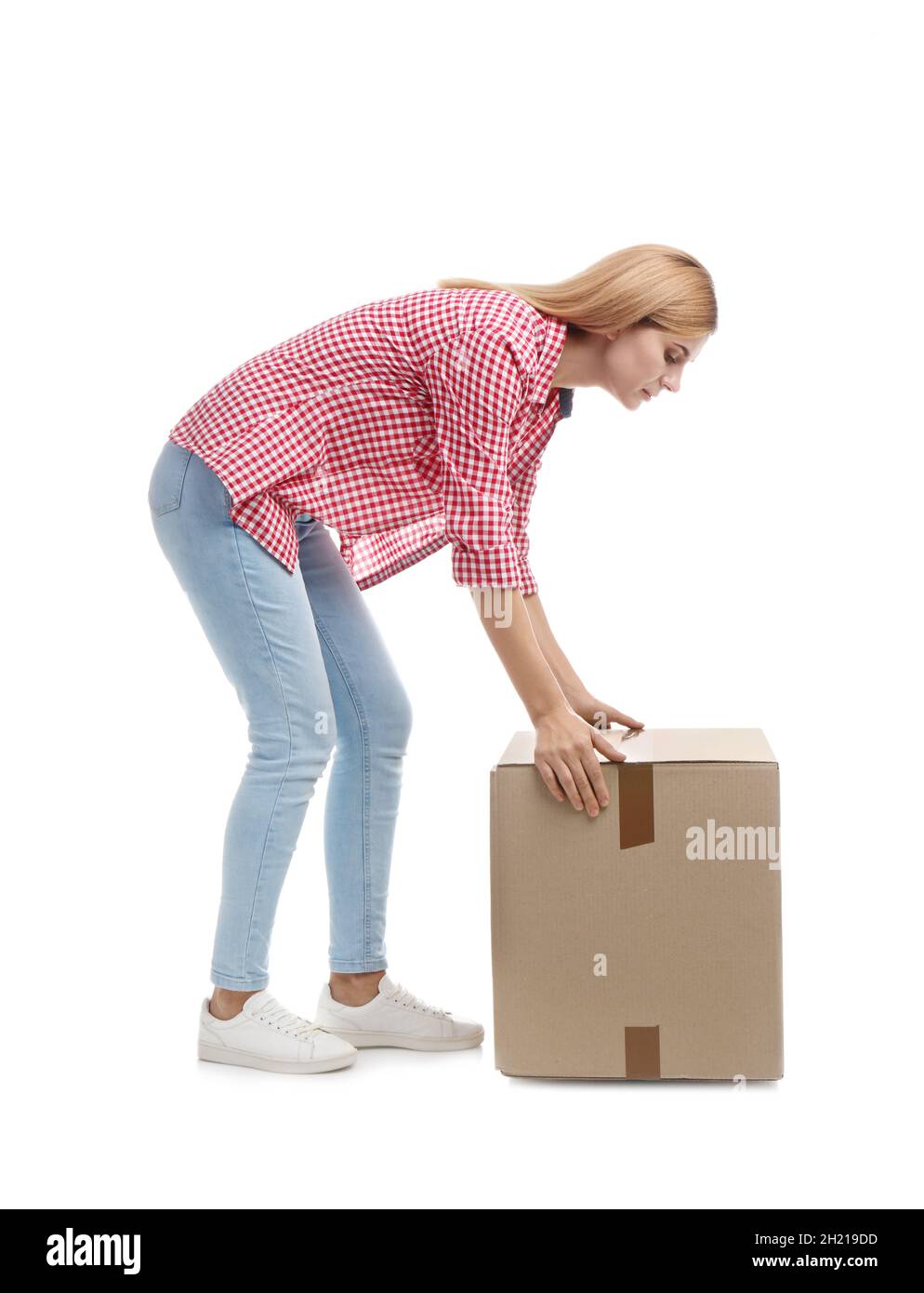 Full length portrait of woman lifting carton box on white background ...
