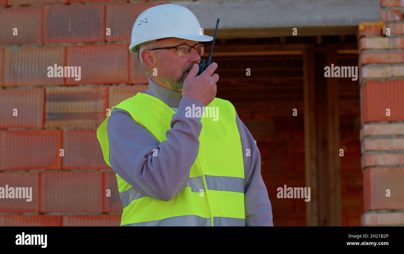 Builder engineer architect operate with radio talking to control ...