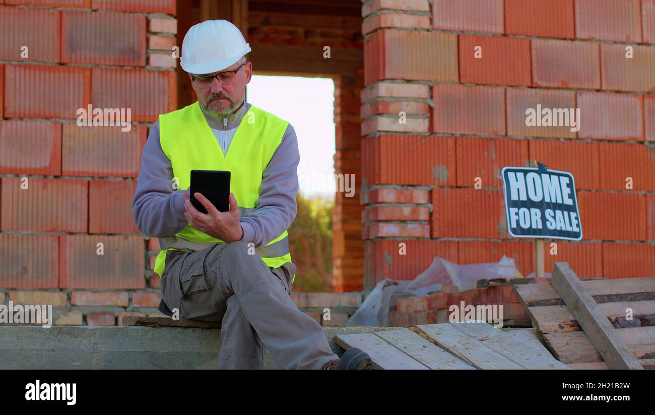 Architect Man With Digital Tablet Computer At Construction Site Analyzing Blueprints Building