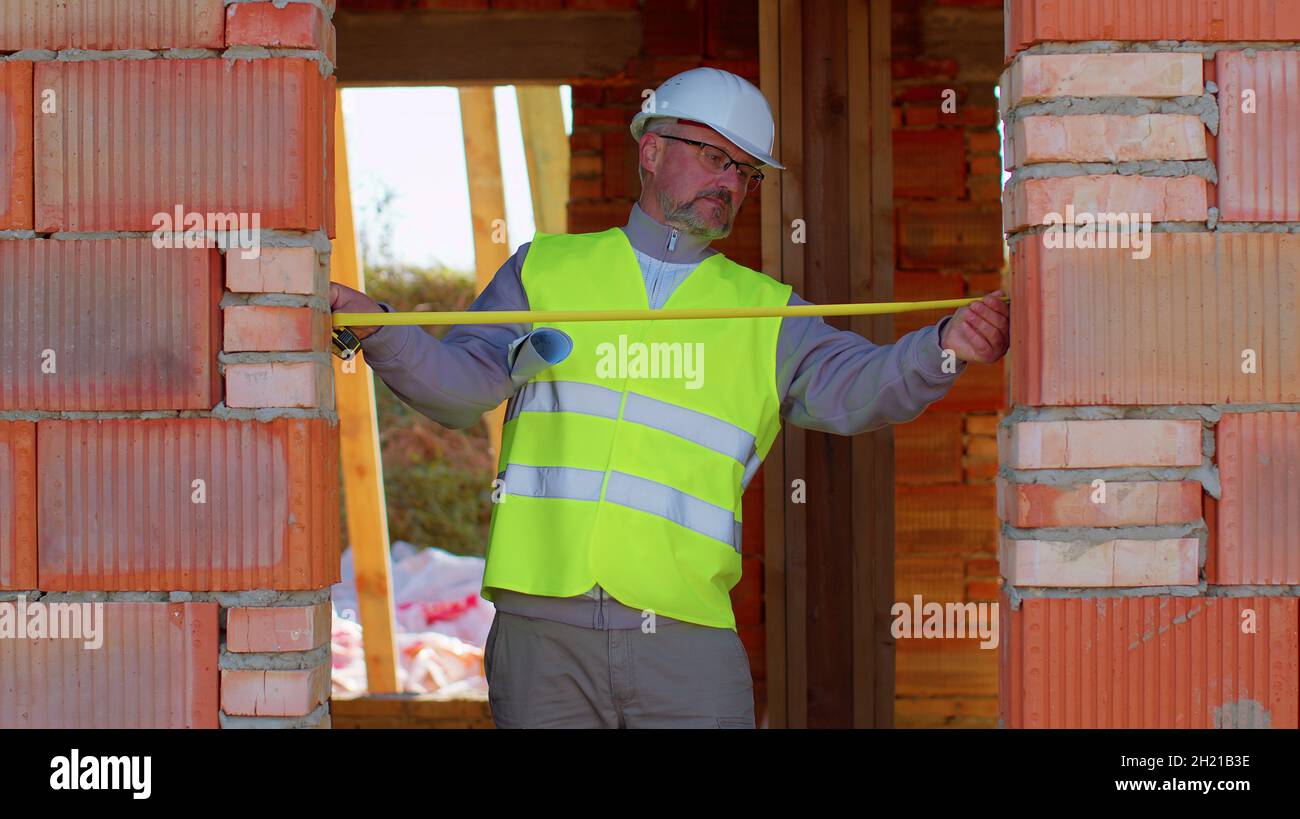 Civil engineer architect specialist conducting measurements with a tape ...