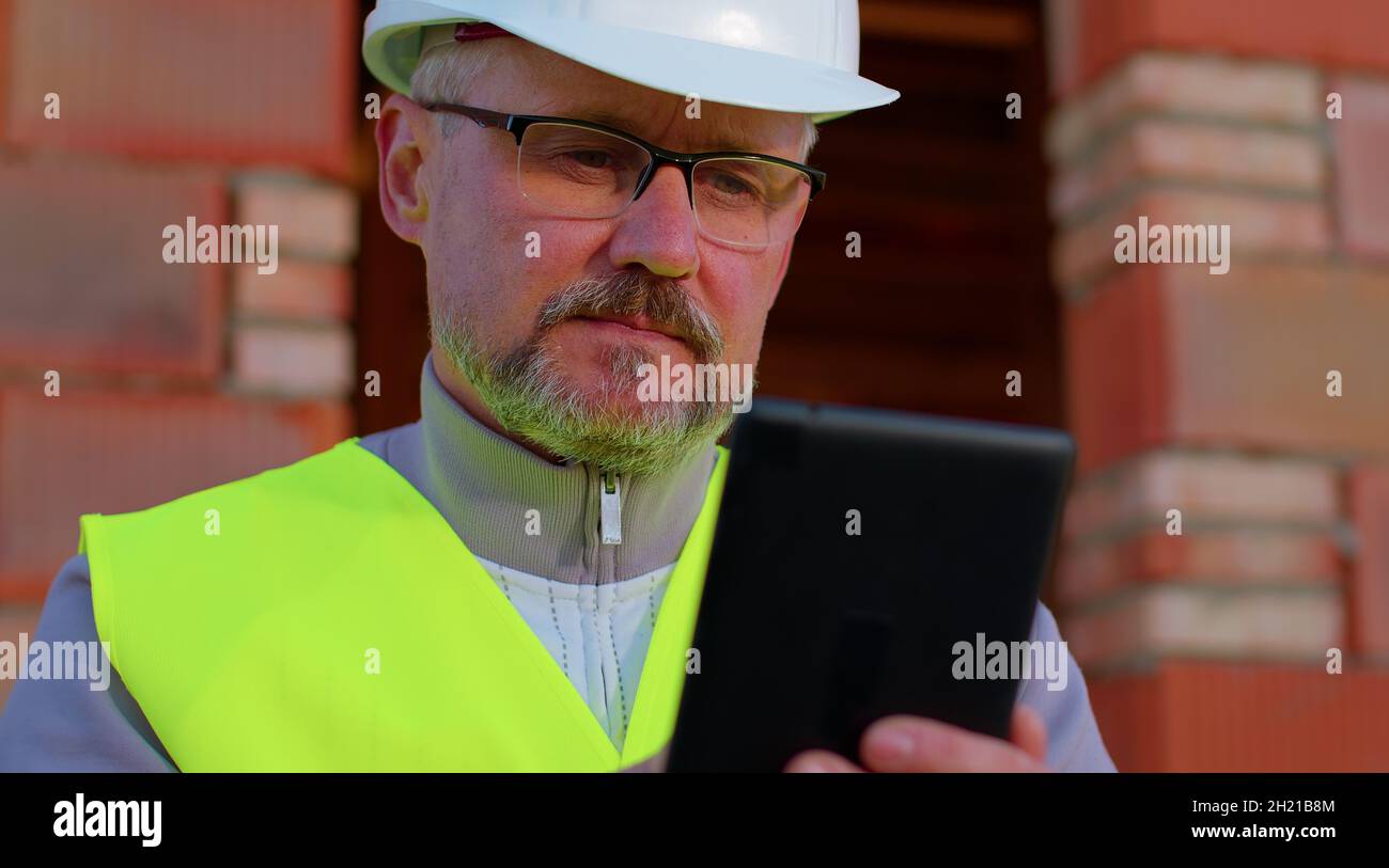Builder engineer architect operate with digital tablet to control ...