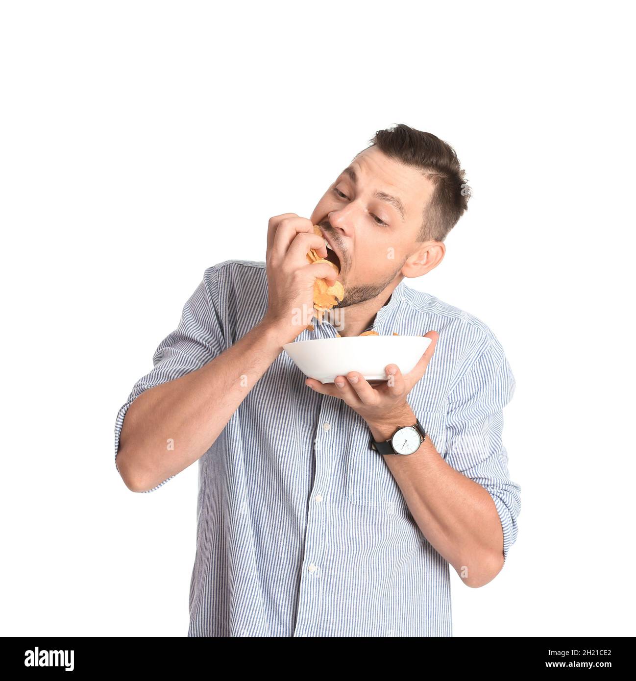 Man eating potato chips on white background Stock Photo - Alamy