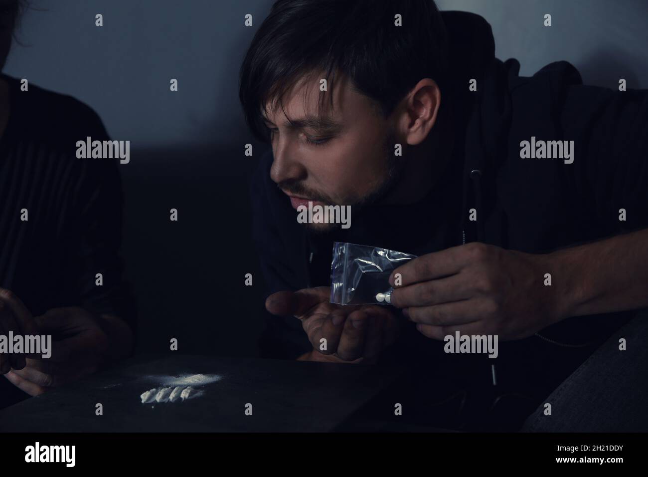 Young addicted men taking drugs on grey background Stock Photo - Alamy