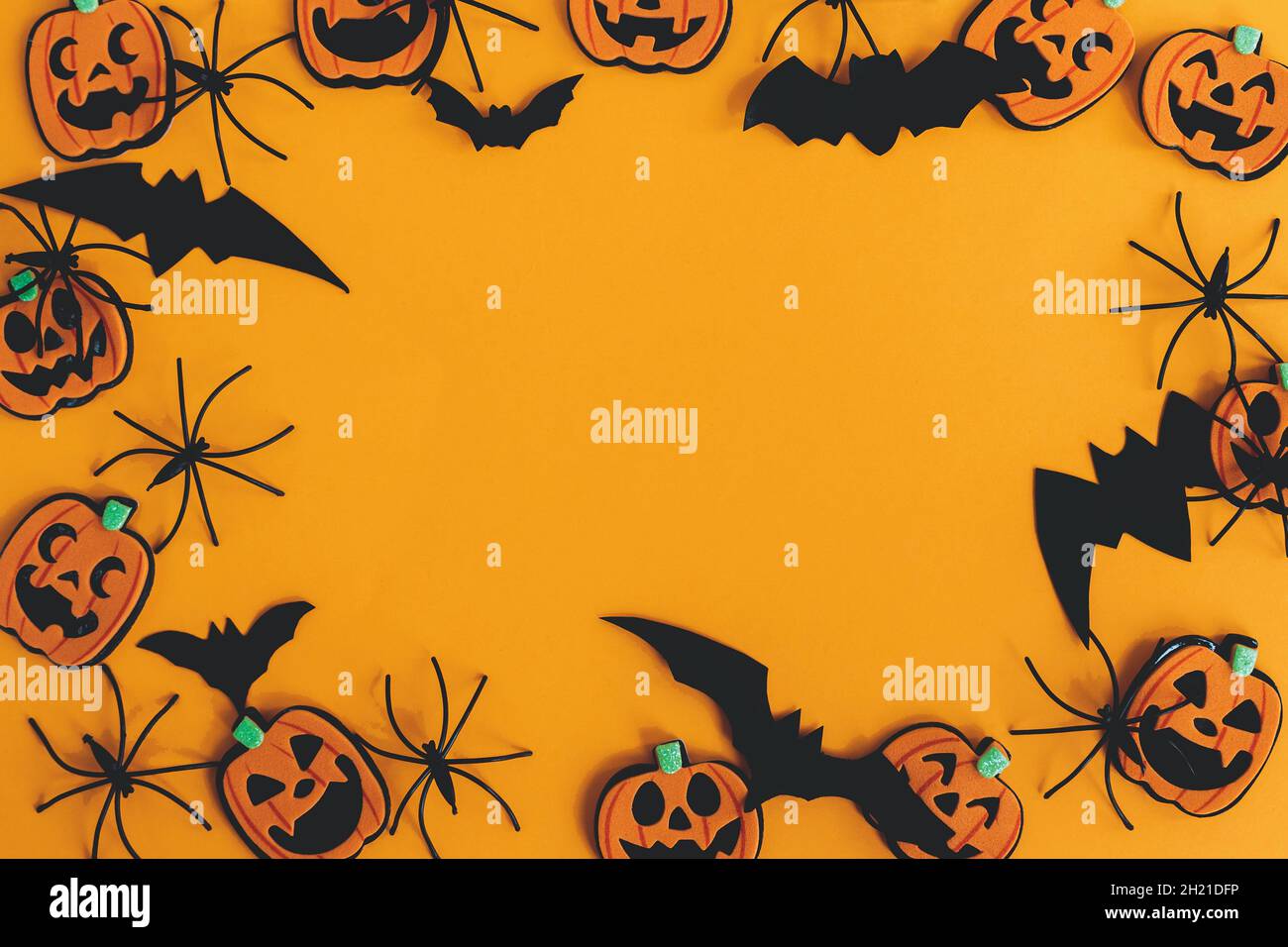 Modern pumpkins jack o lantern, spiders, bats frame flat lay on orange ...