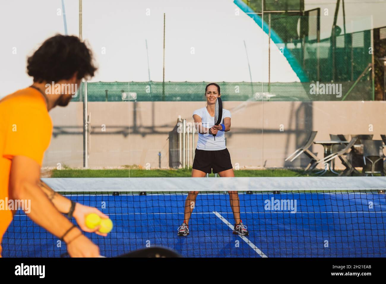 Young teacher is monitoring teaching padel lesson to his student ...
