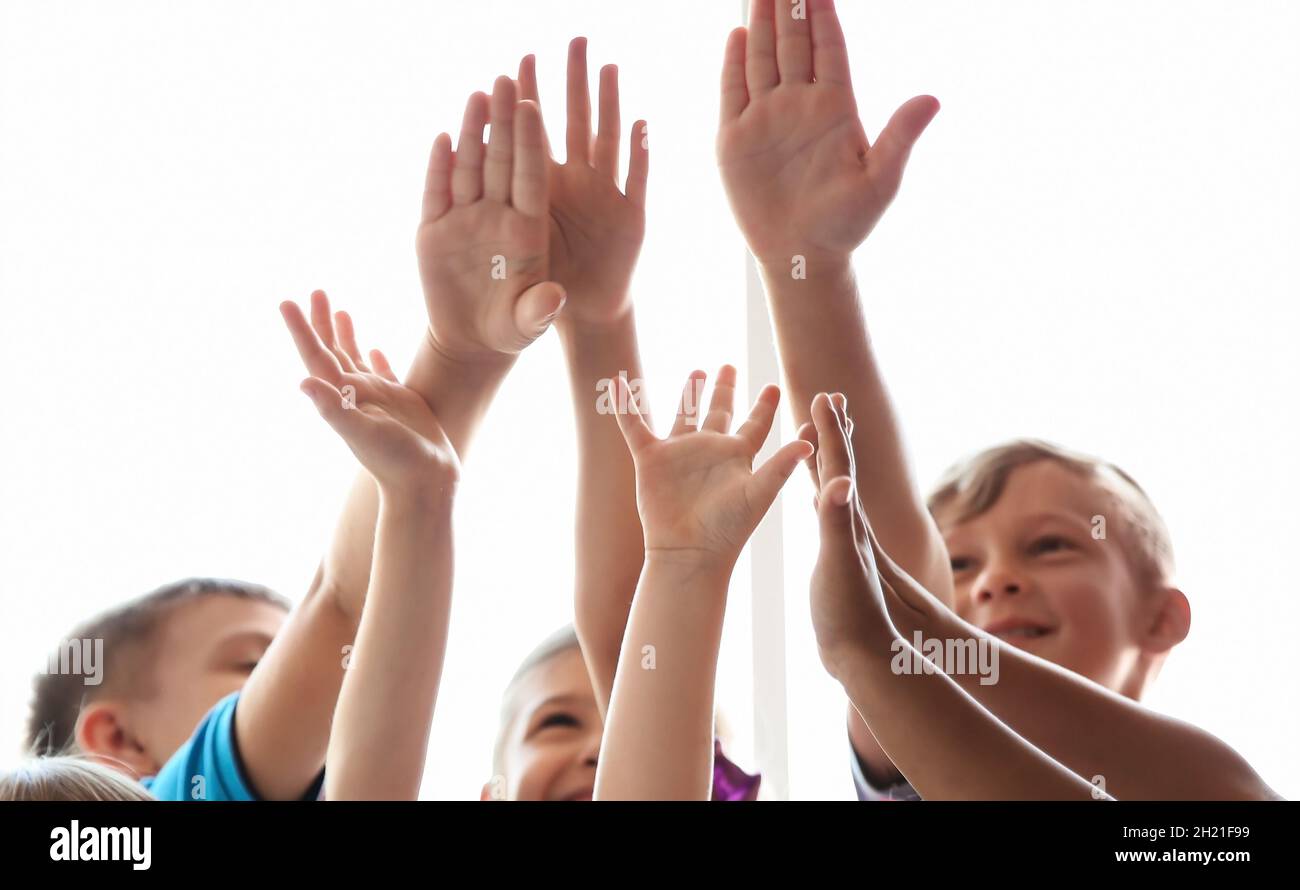 Little children raising hands together on light background. Unity ...