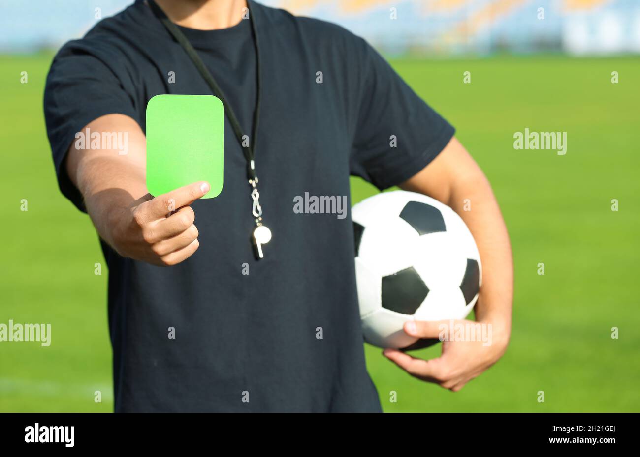 Football referee showing green card at stadium, closeup Stock Photo - Alamy