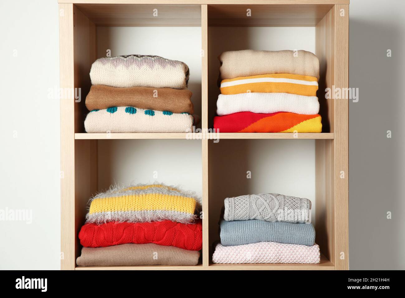 Stacks of folded winter clothes on shelves in wardrobe Stock Photo - Alamy