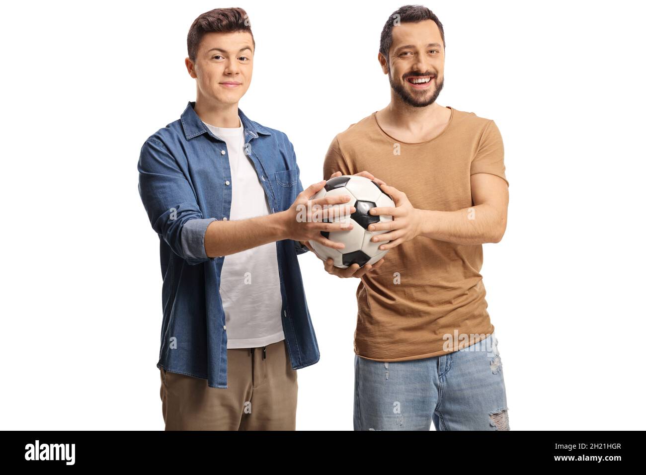 Two young men holding a football together isolated on white background ...