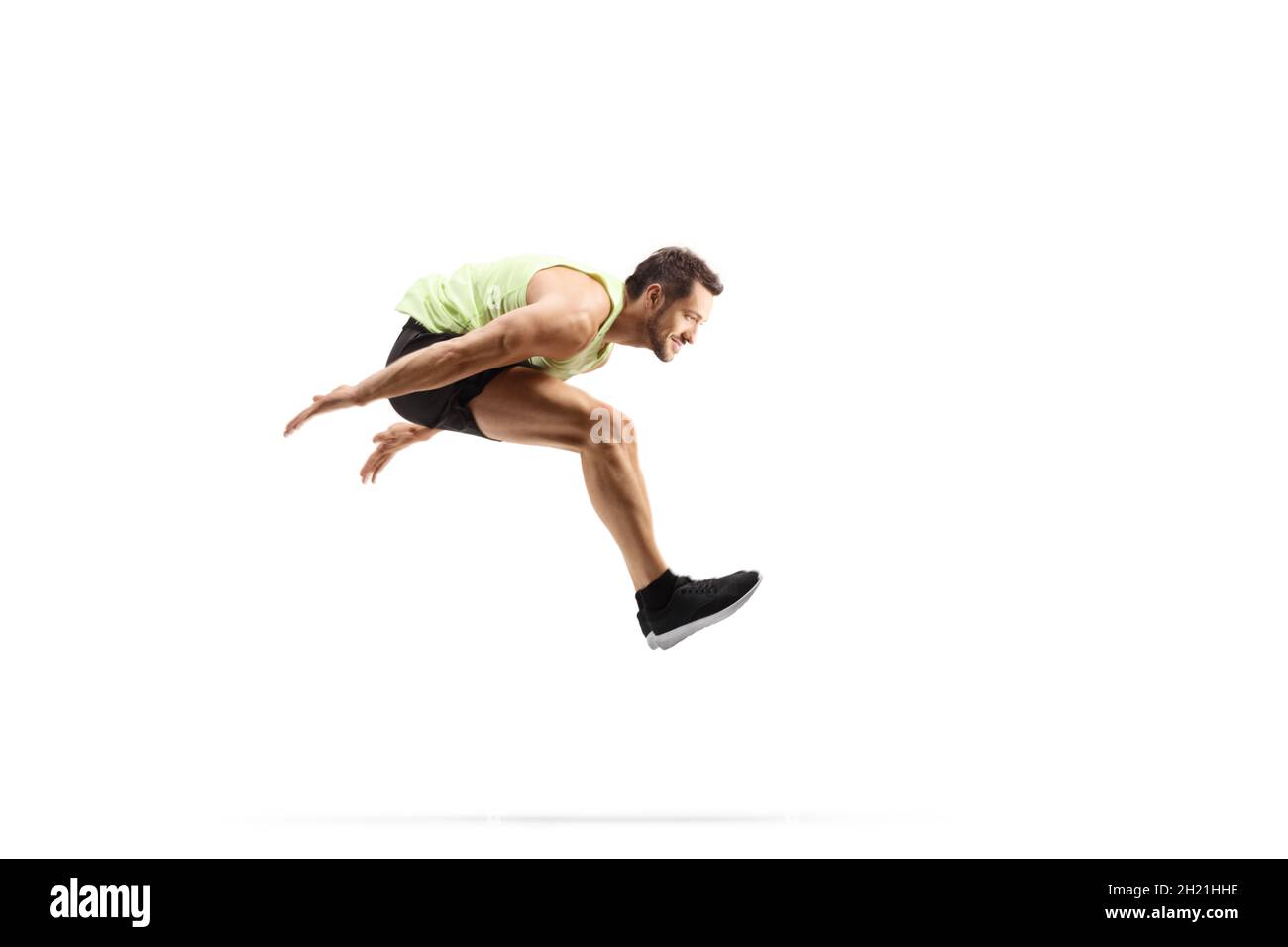Full length profile shot of a male athlete performing a long jump ...