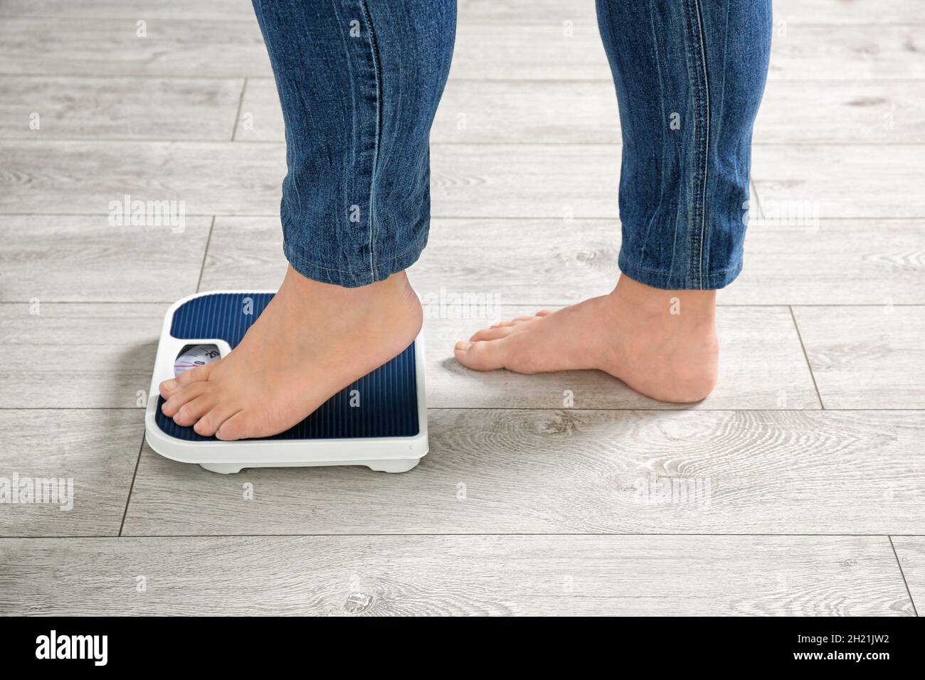 Overweight woman using scales indoors Stock Photo - Alamy